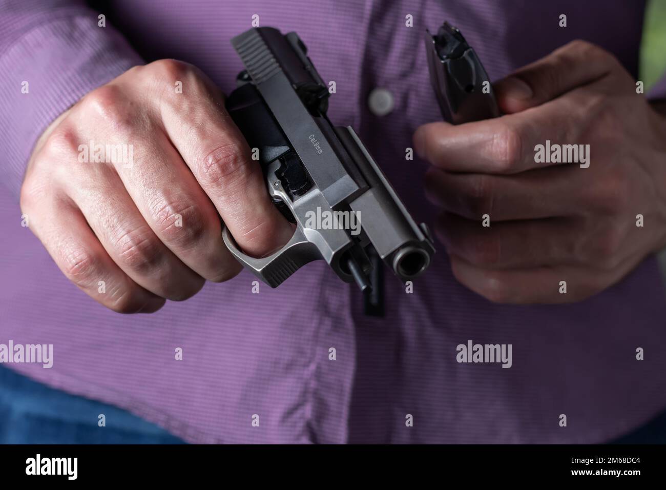 A man holds an empty pistol and clip in his hands Stock Photo - Alamy