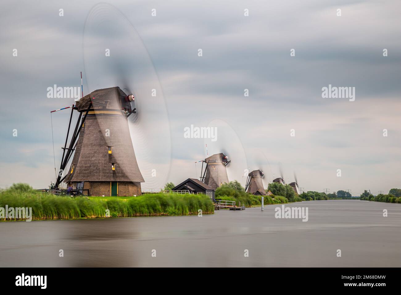 windmills pumps at a canal in a row long exposure at kinderdijk ...