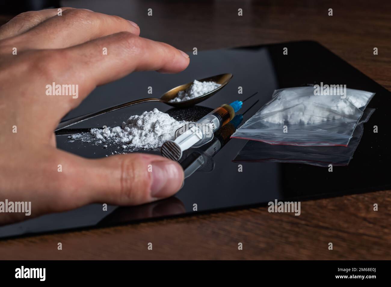 The concept of anti drugs. Drug addict reaches for another dose of the ...