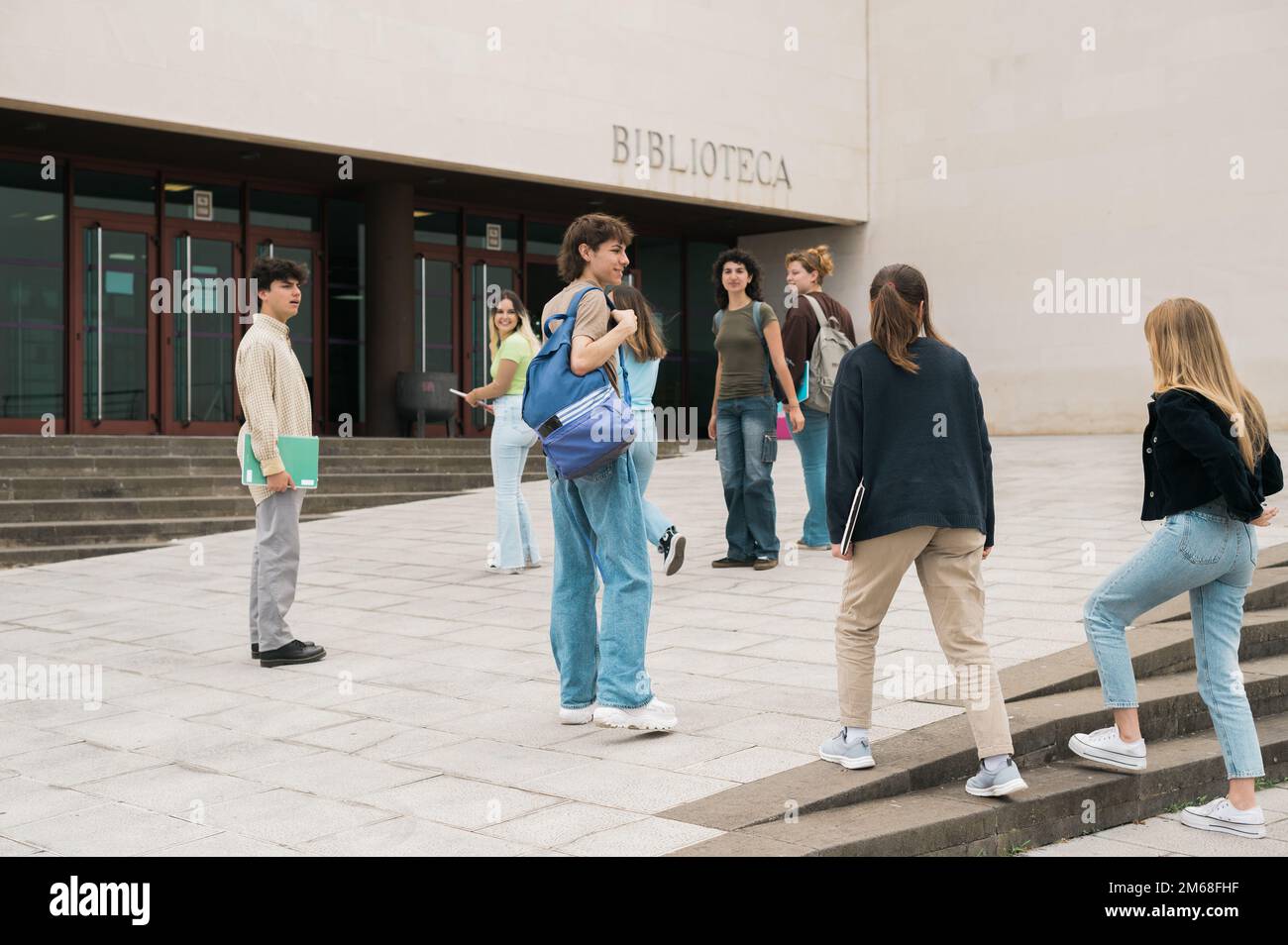 Young groupmates gathered near university before studies Stock Photo ...