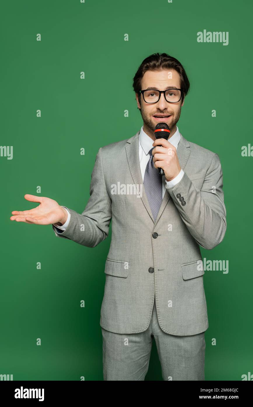 news anchor in suit talking at microphone and pointing with hand on ...