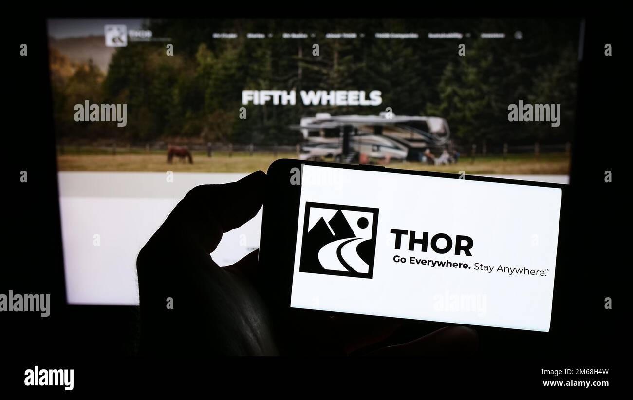 Person holding cellphone with logo of American RV manufacturing company ...