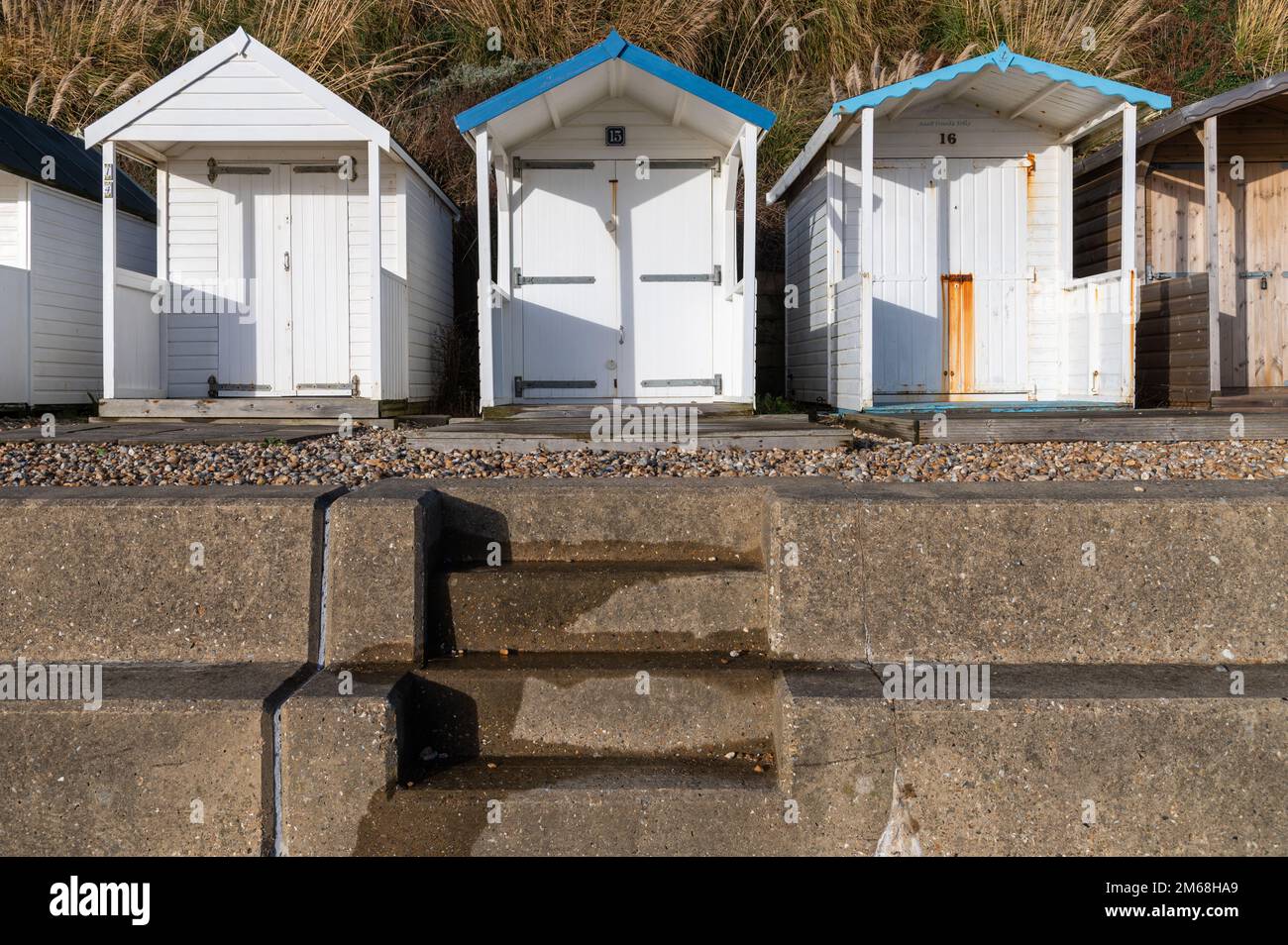Three white wooden beach huts at Bexhill-on-Sea on a sunny day Stock ...