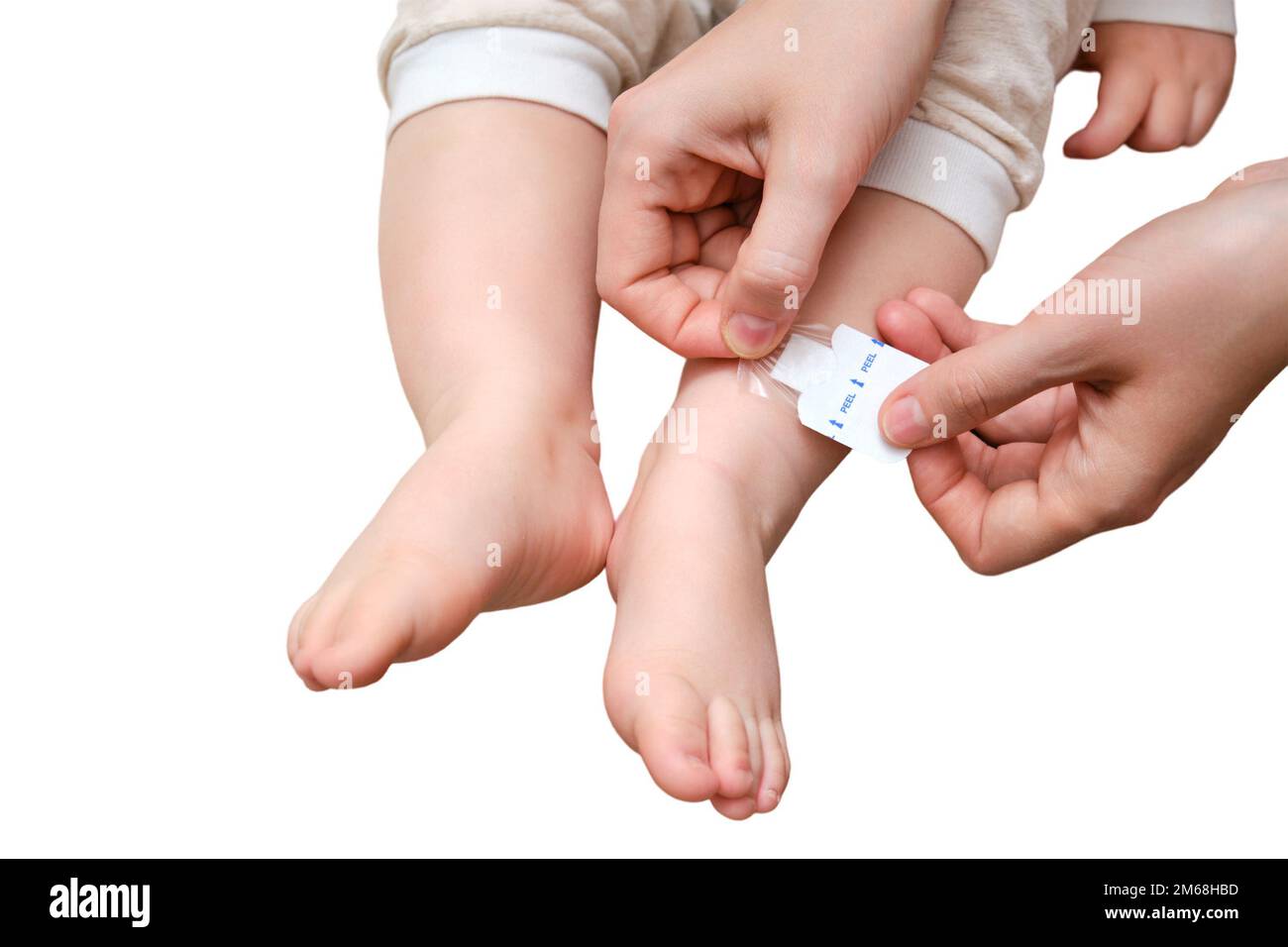 Mother woman sticks a medical adhesive plaster on the toddler baby leg ...