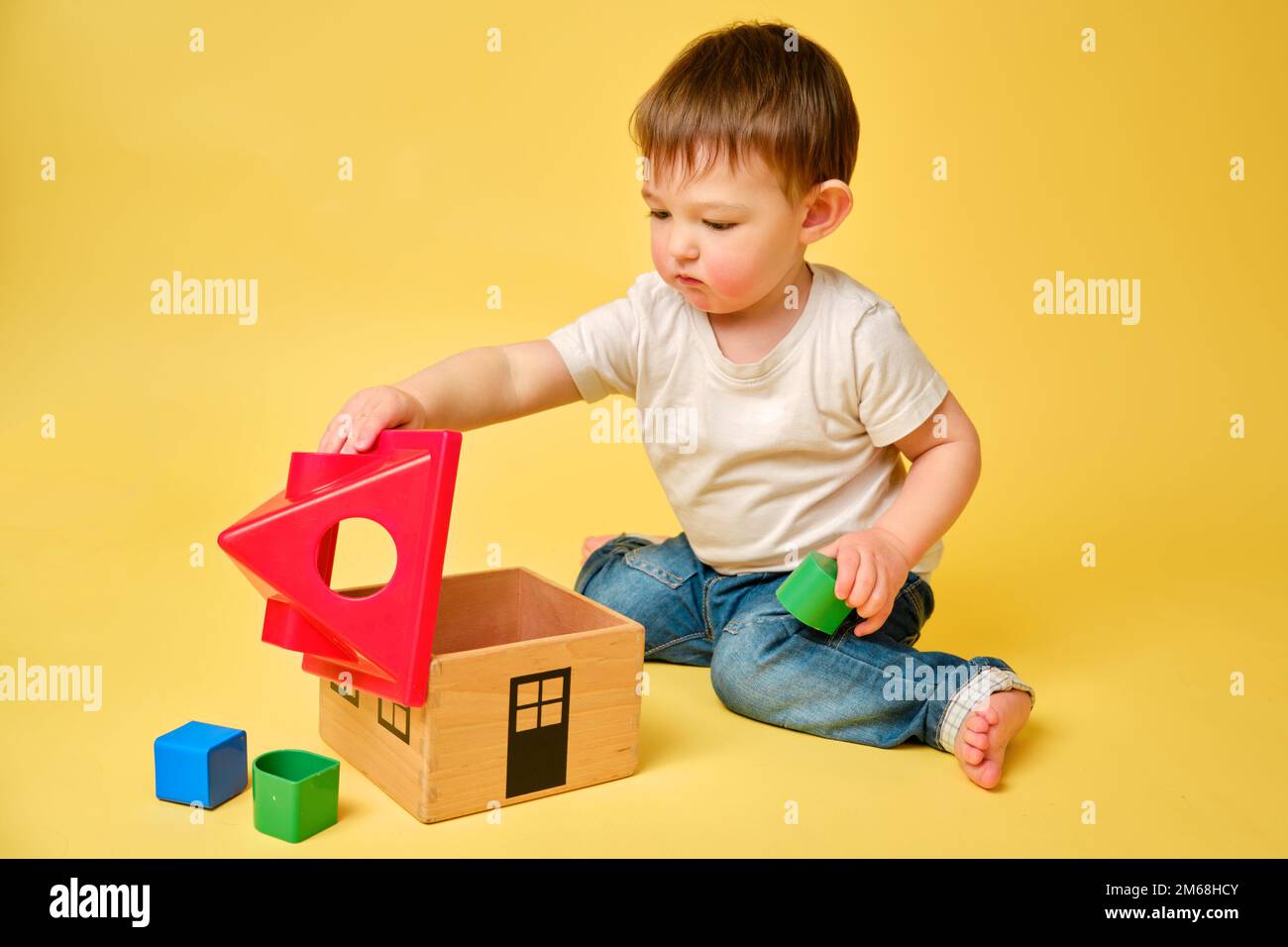 Toddler baby is playing sorter logic educational games with geometric ...