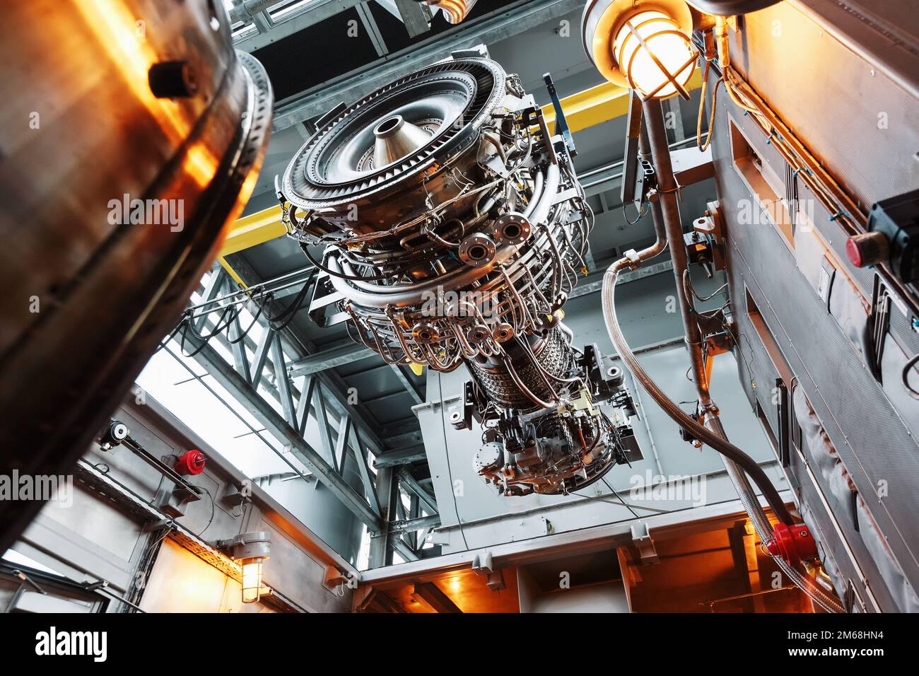 The engine of a gas turbine compressor hangs on a crane during ...