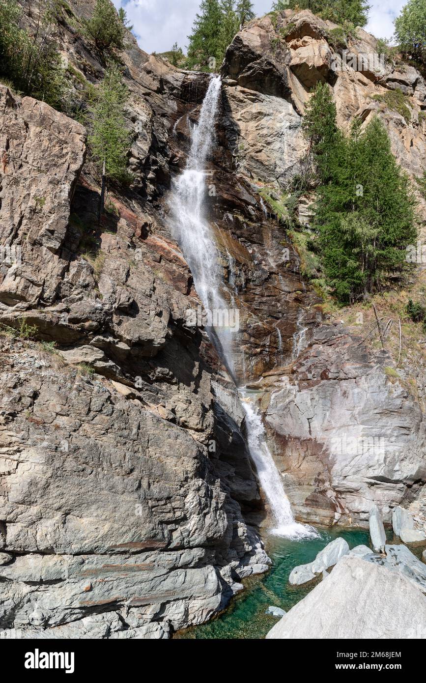 Streams of water rush over granite rapids into emerald lake they formed ...
