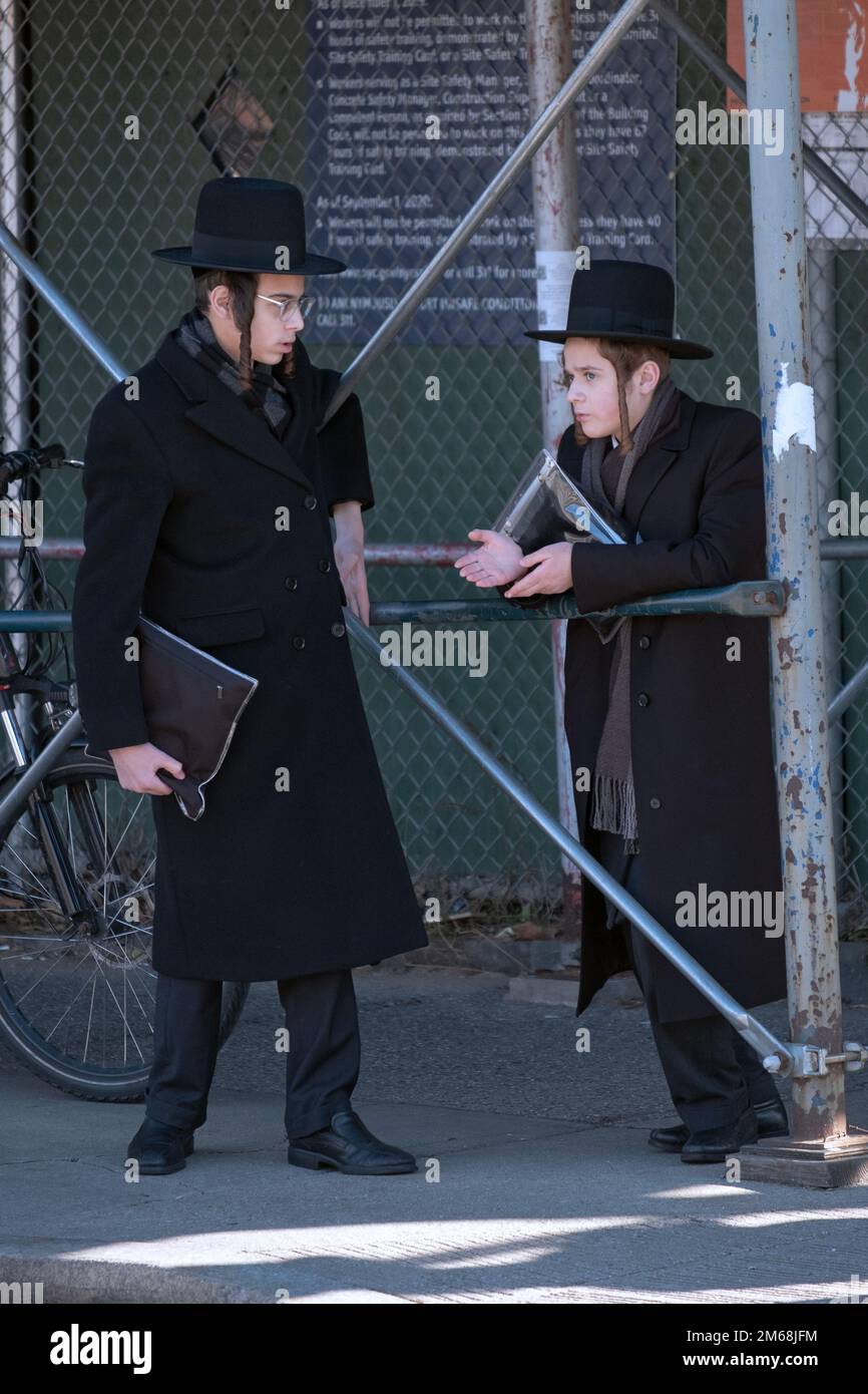 Hasidic teenagers with long curled peyot have a chat after morning ...