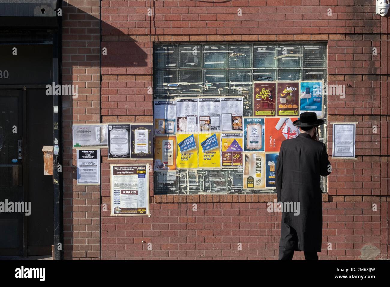 An ultra orthodox Jewish man reads a community bulletin board that are ...