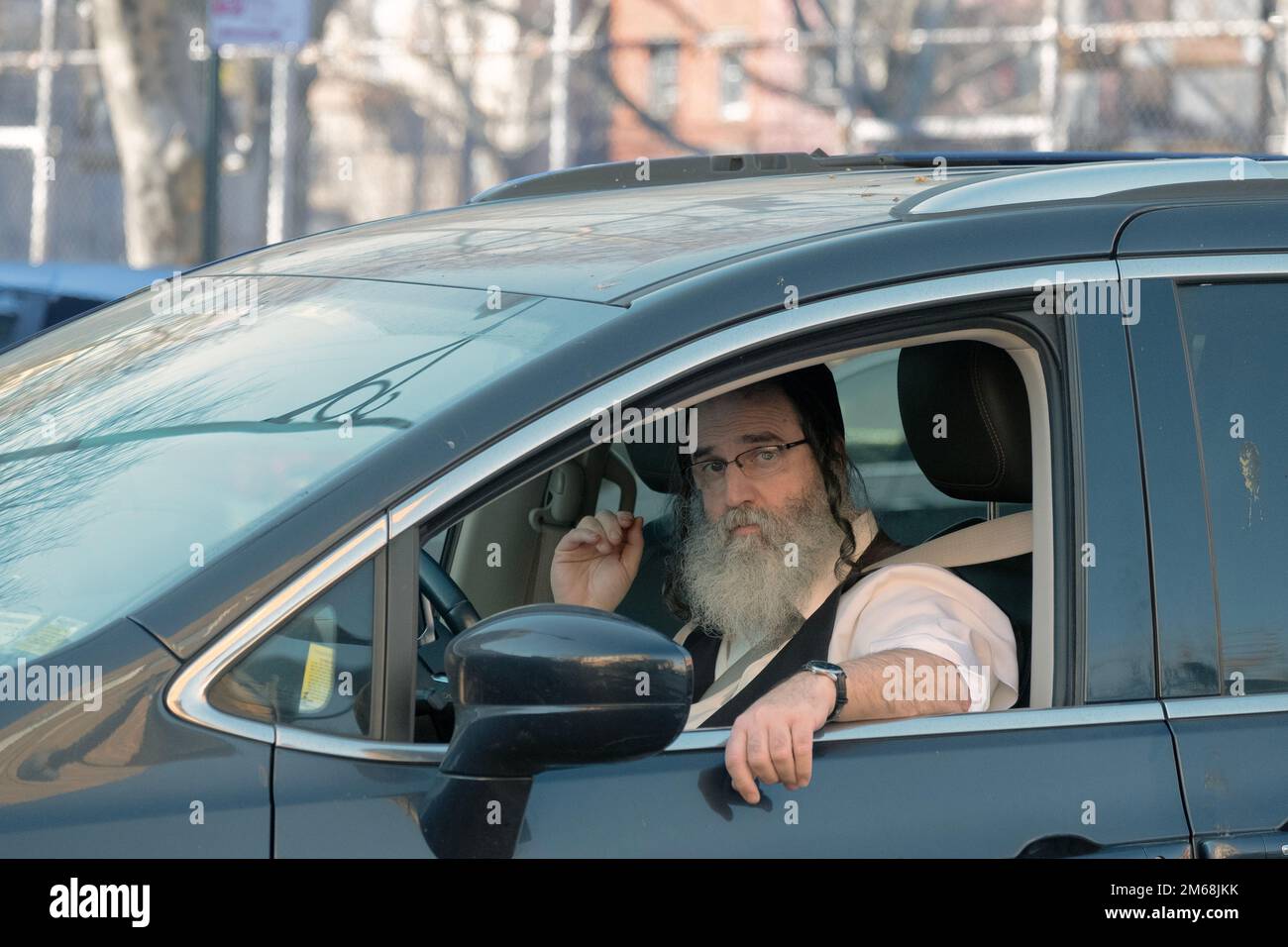 An orthodox jewish man in an SUV and stopped for a traffic light. In ...
