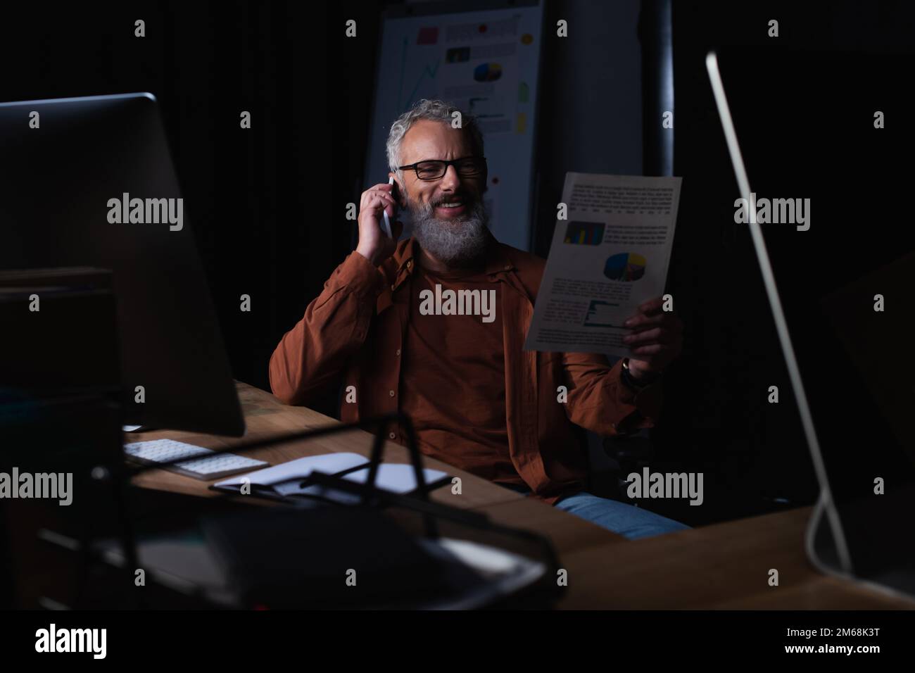 happy middle aged businessman calling on mobile phone while looking at ...