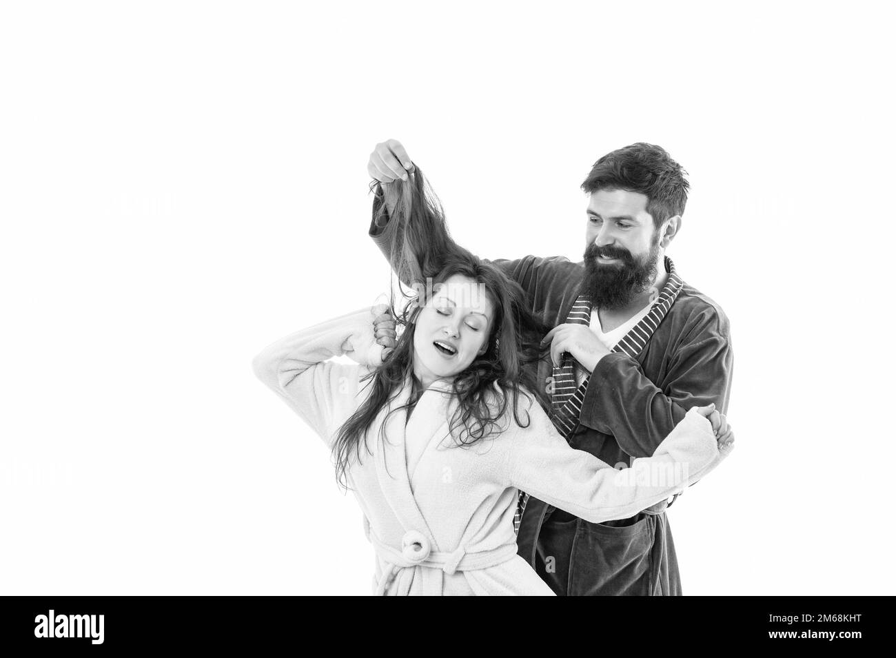 Happy family of man having fun with hair of woman sleeping and yawning ...