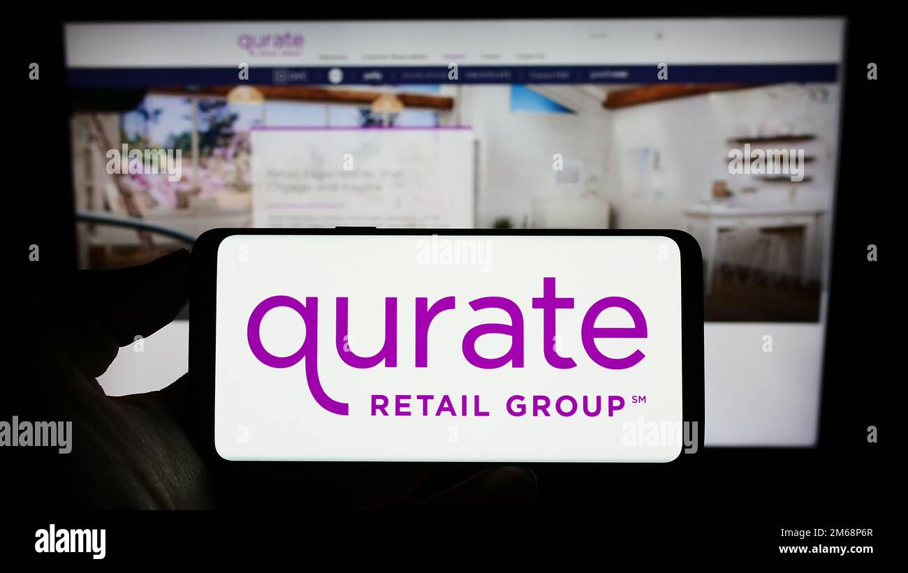 Person holding cellphone with logo of US media company Qurate Retail ...