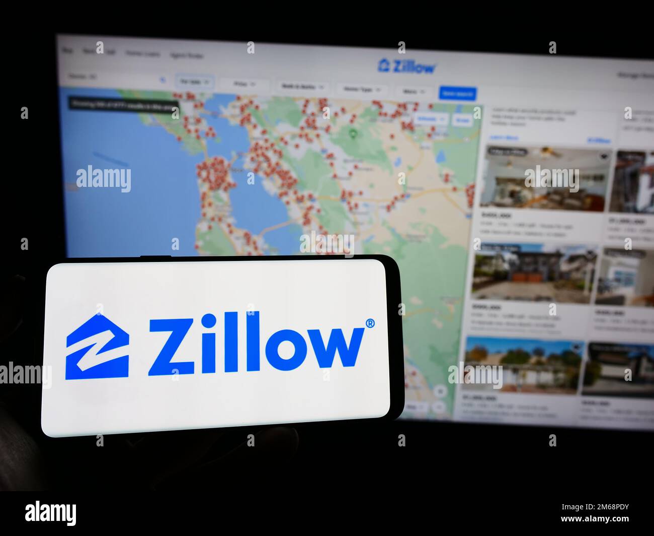 Person holding cellphone with logo of US real estate marketplace Zillow ...