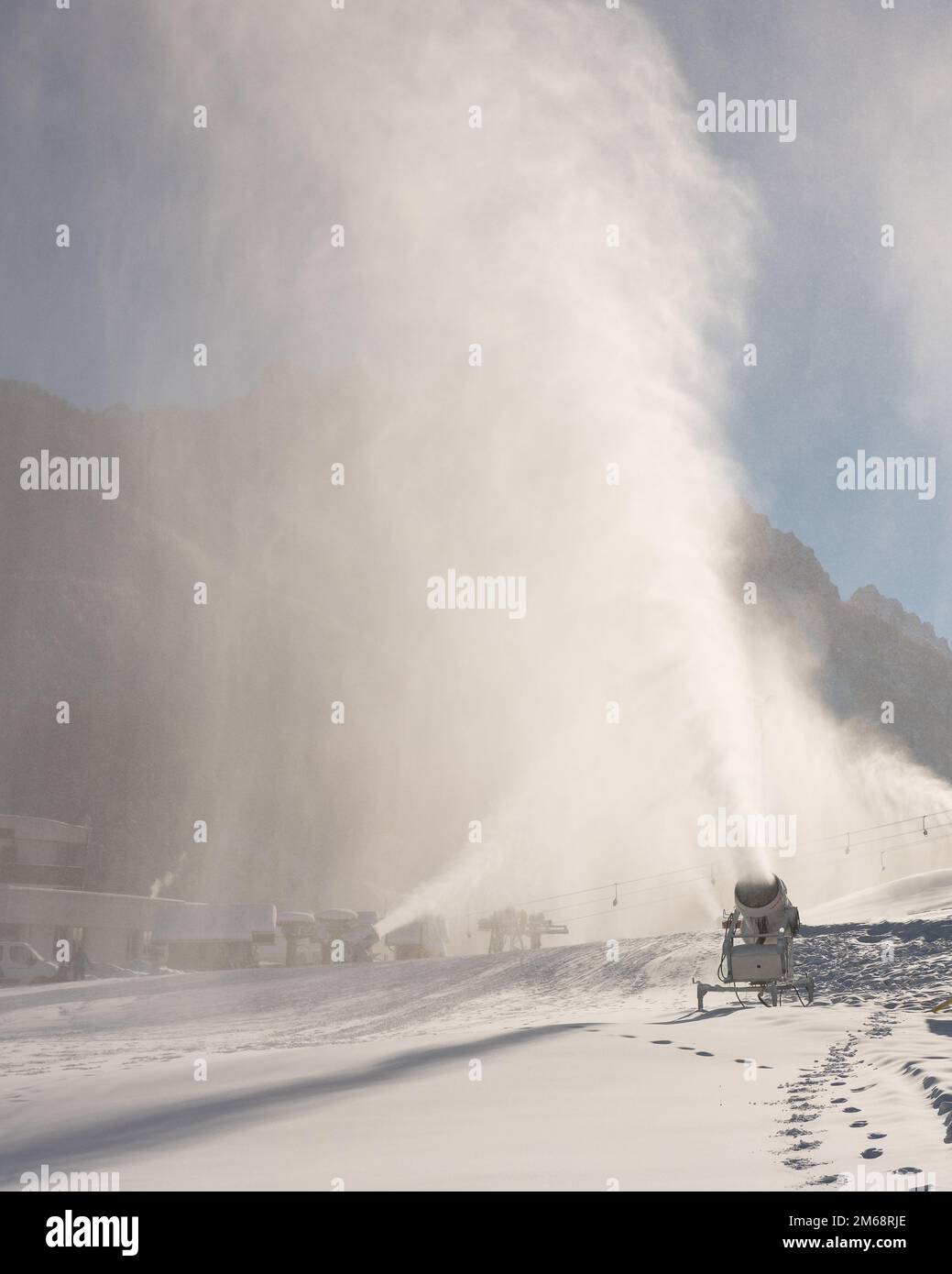 Snowmaking machine snow cannon or gun in action on a cold sunny winter ...