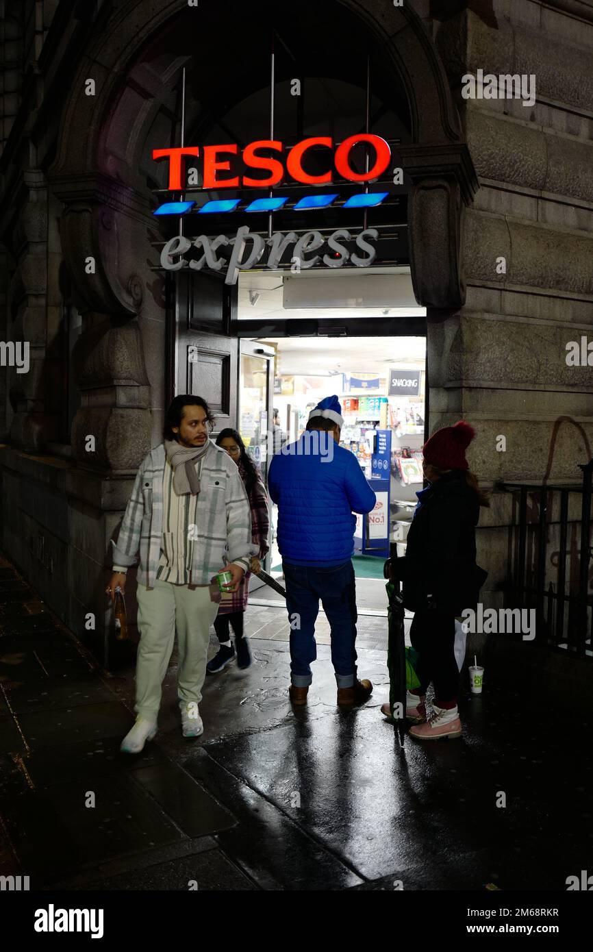 people walking and out of tesco express at night Stock Photo - Alamy