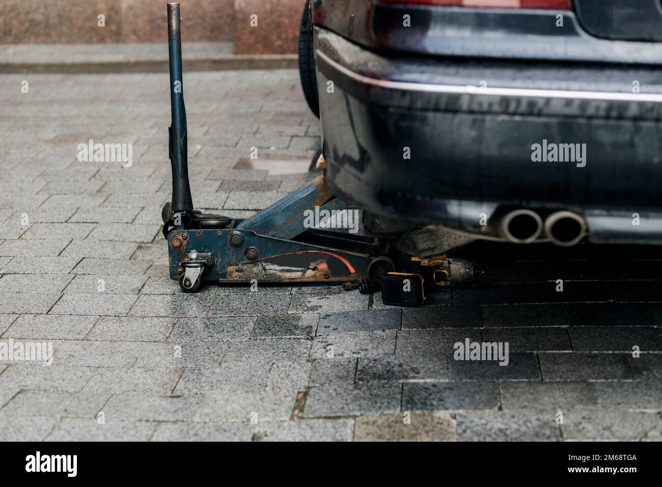 wheel removed, lifted by hydraulic jack, car repair on the roadside ...