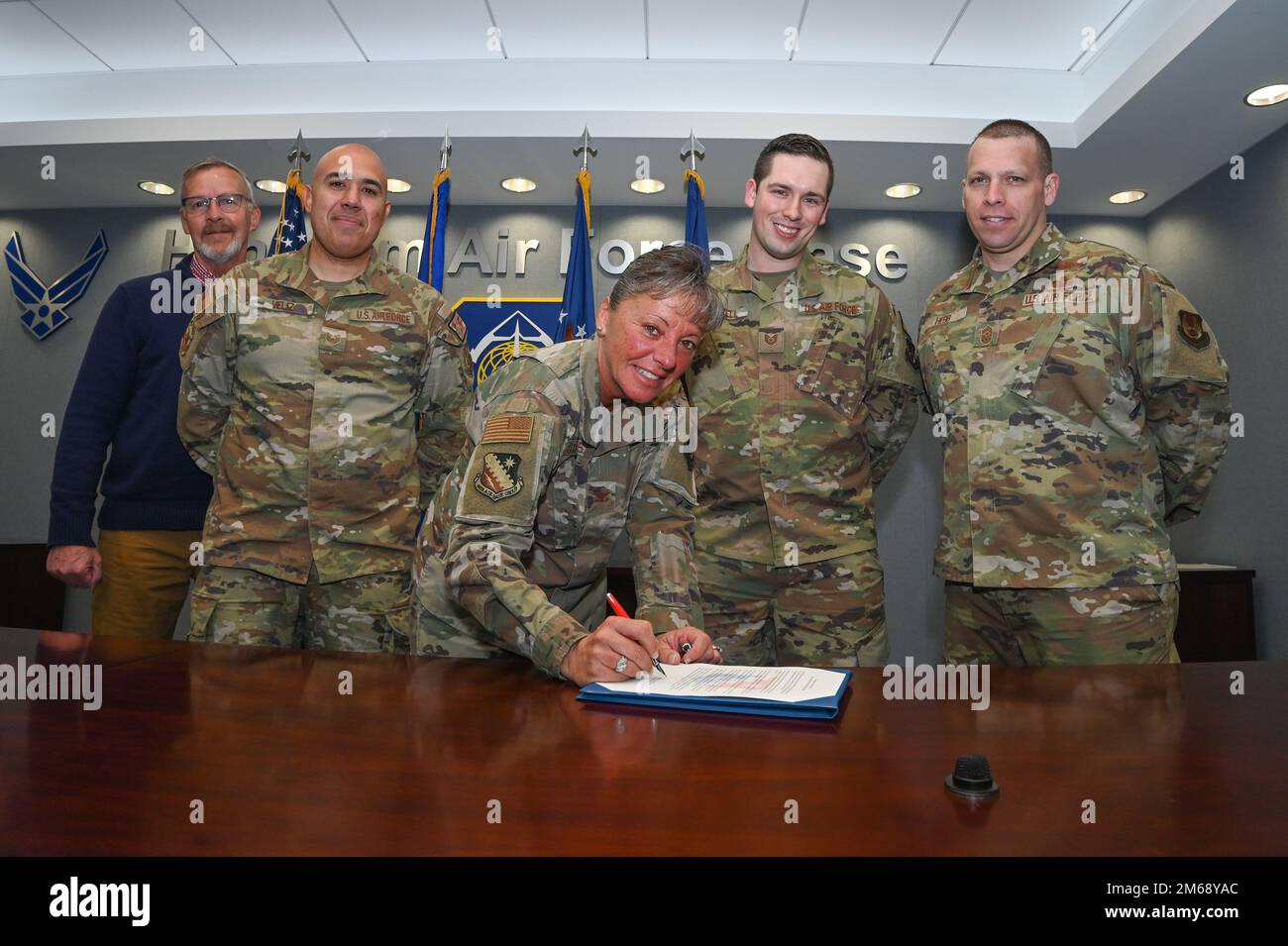 Col. Katrina Stephens, center, installation commander, signs a ...