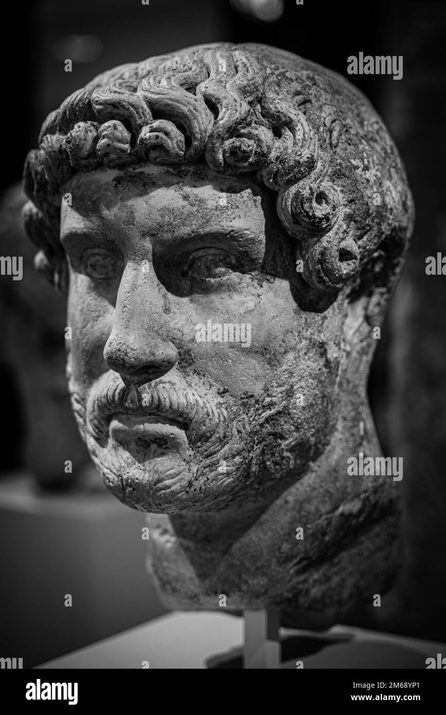 A vertical grayscale of a Roman statue in the Roman Germanic Museum in ...