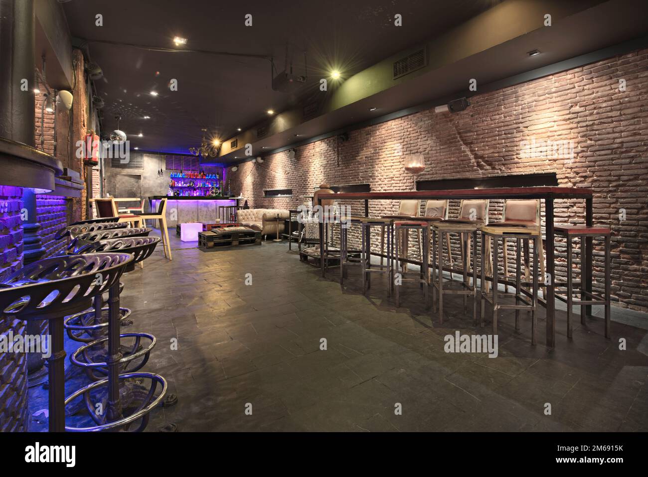 Room of a commercial premises with long high tables and stools in an ...