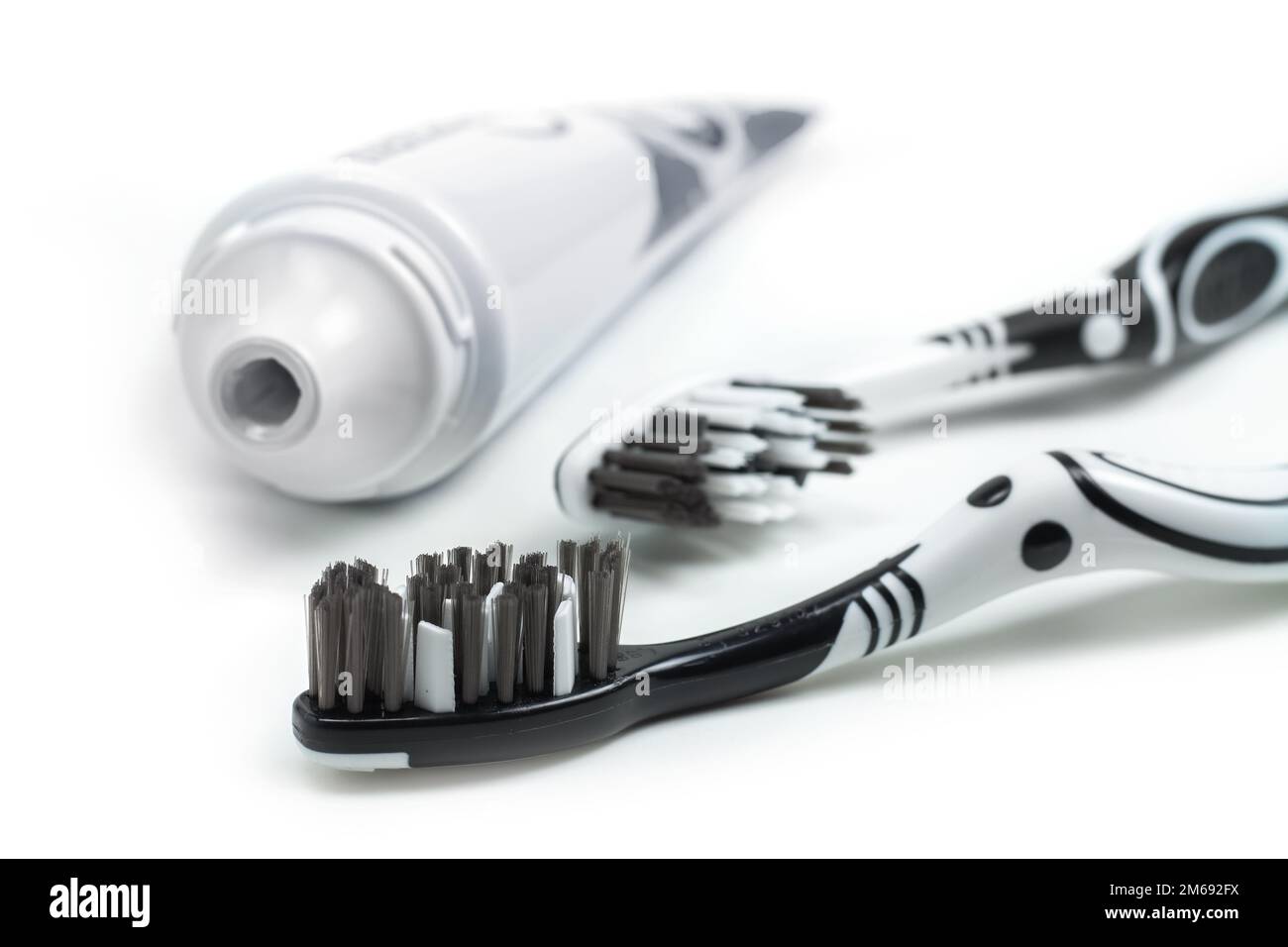 A black and white toothbrush with toothpaste on white background with ...