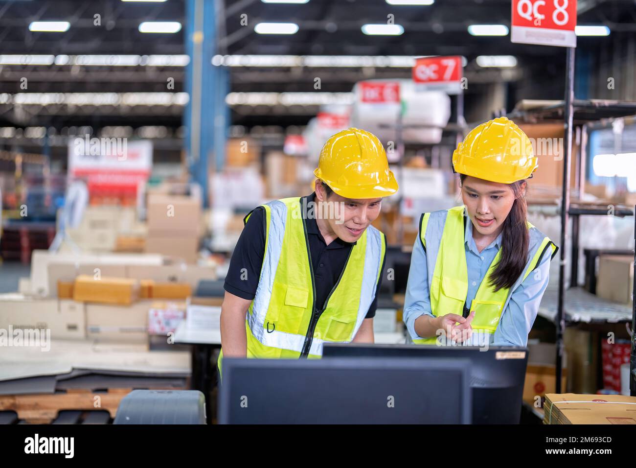 Staff working in large depot storage warehouse trainee check packing ...