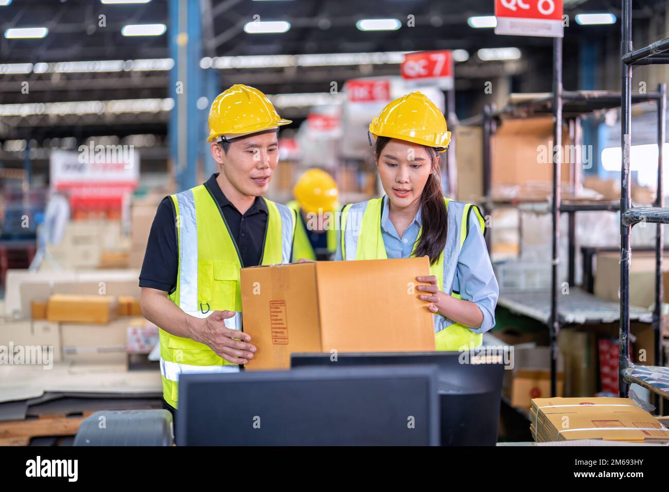 Staff working in large depot storage warehouse trainee check packing ...