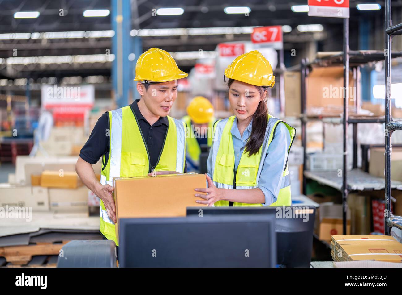 Staff working in large depot storage warehouse trainee check packing ...