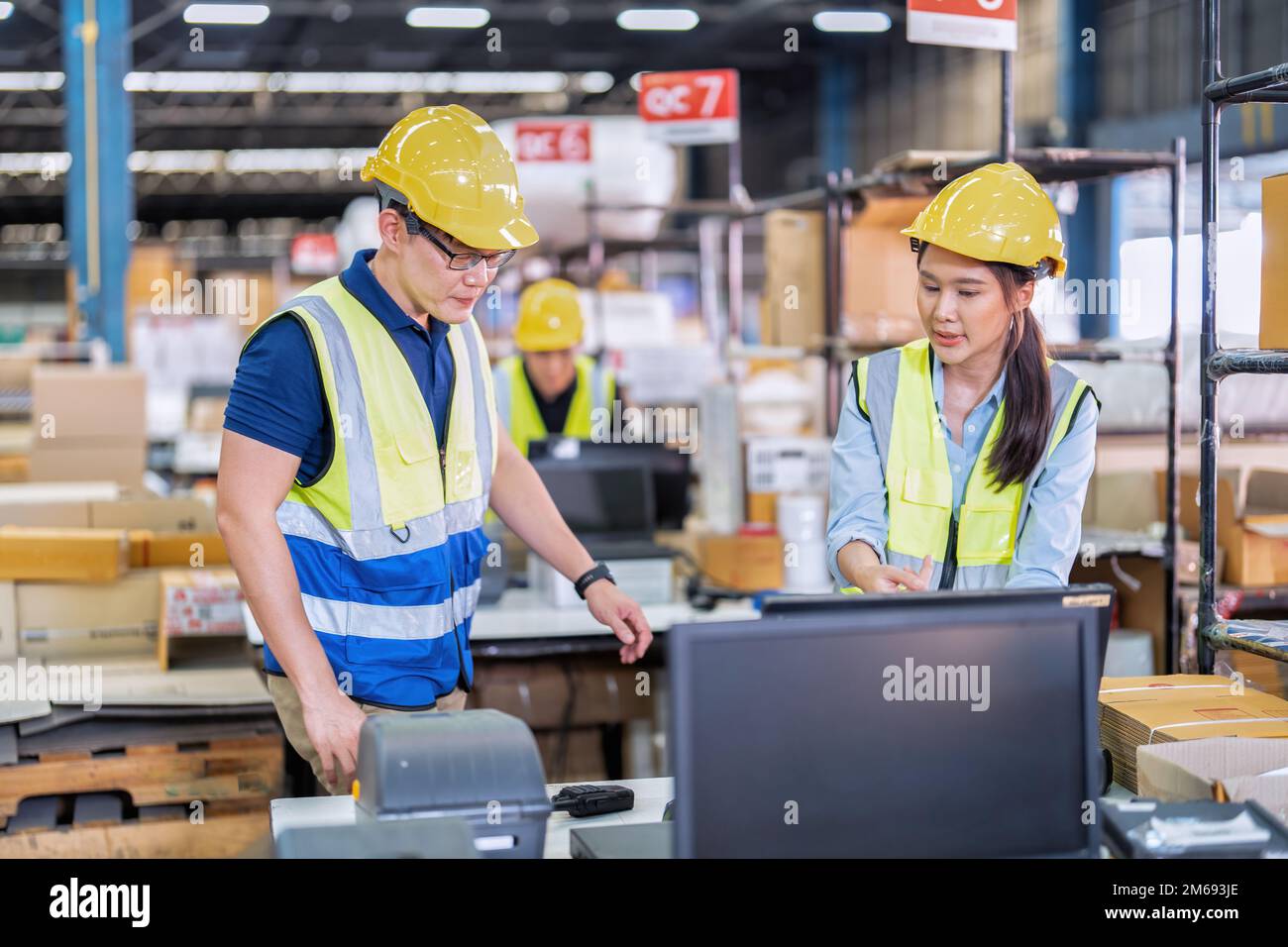 Staff working in large depot storage warehouse trainee check packing ...