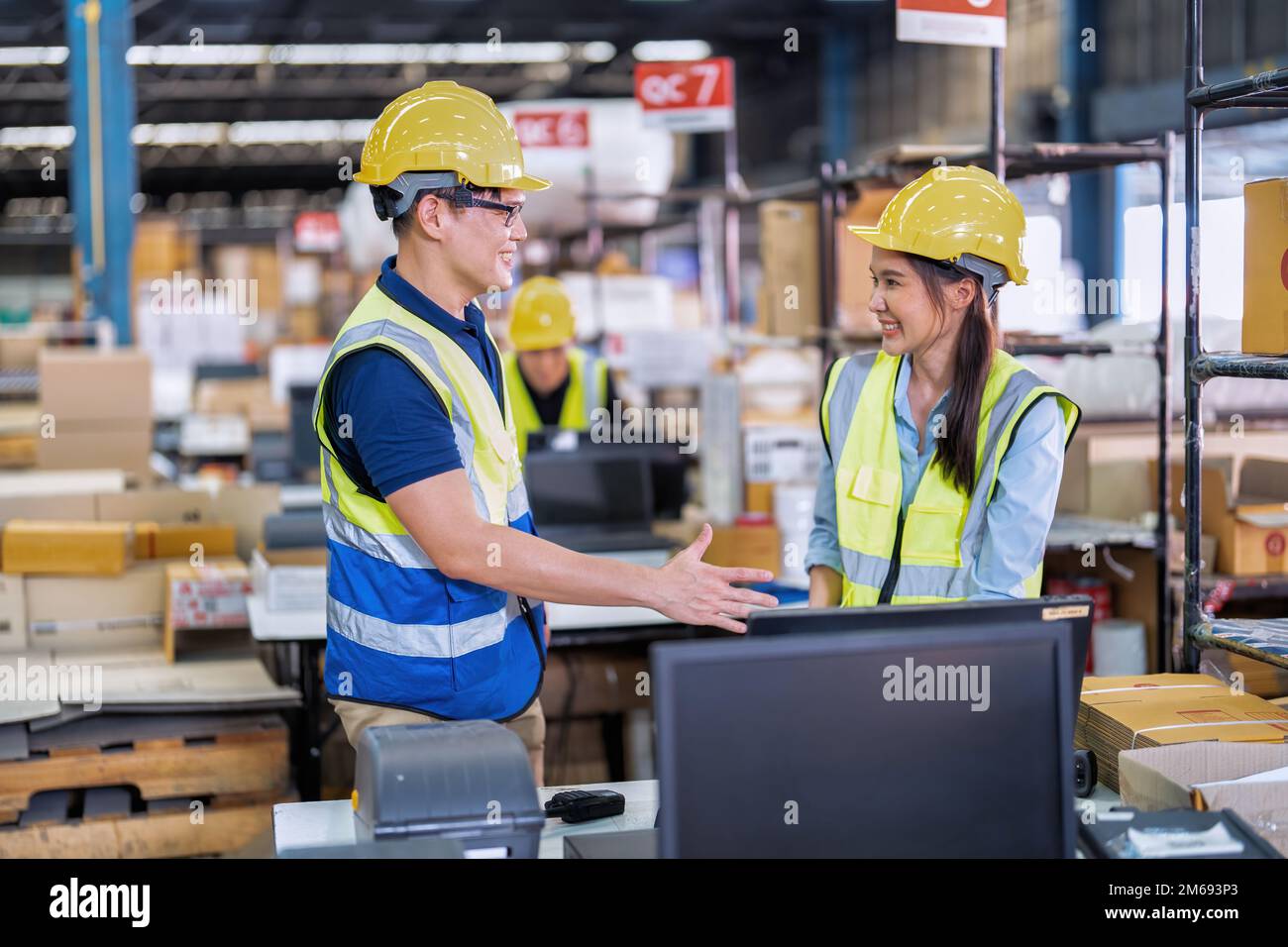 Staff working in large depot storage warehouse trainee check packing ...