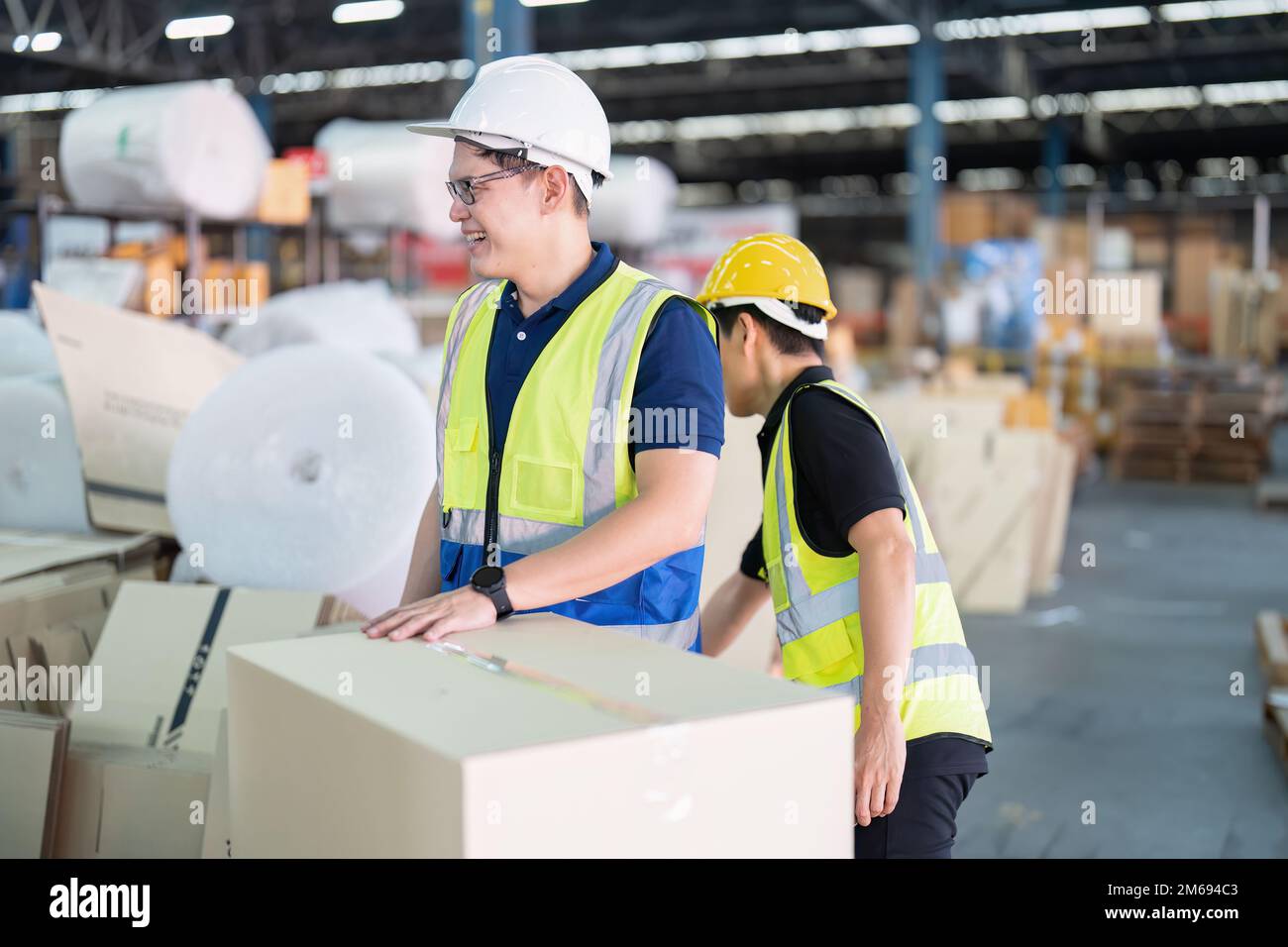 Staff in large storage warehouse together packing goods and carry ...
