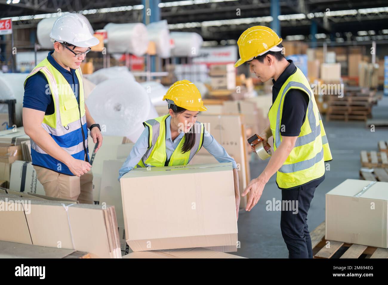 Staff in large storage warehouse together packing goods and carry ...