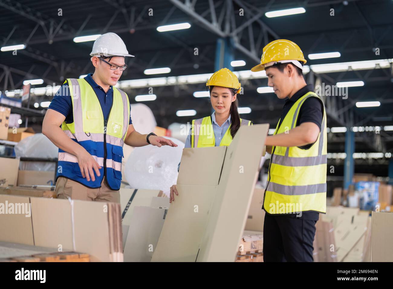 Staff in large storage warehouse together packing goods and carry ...
