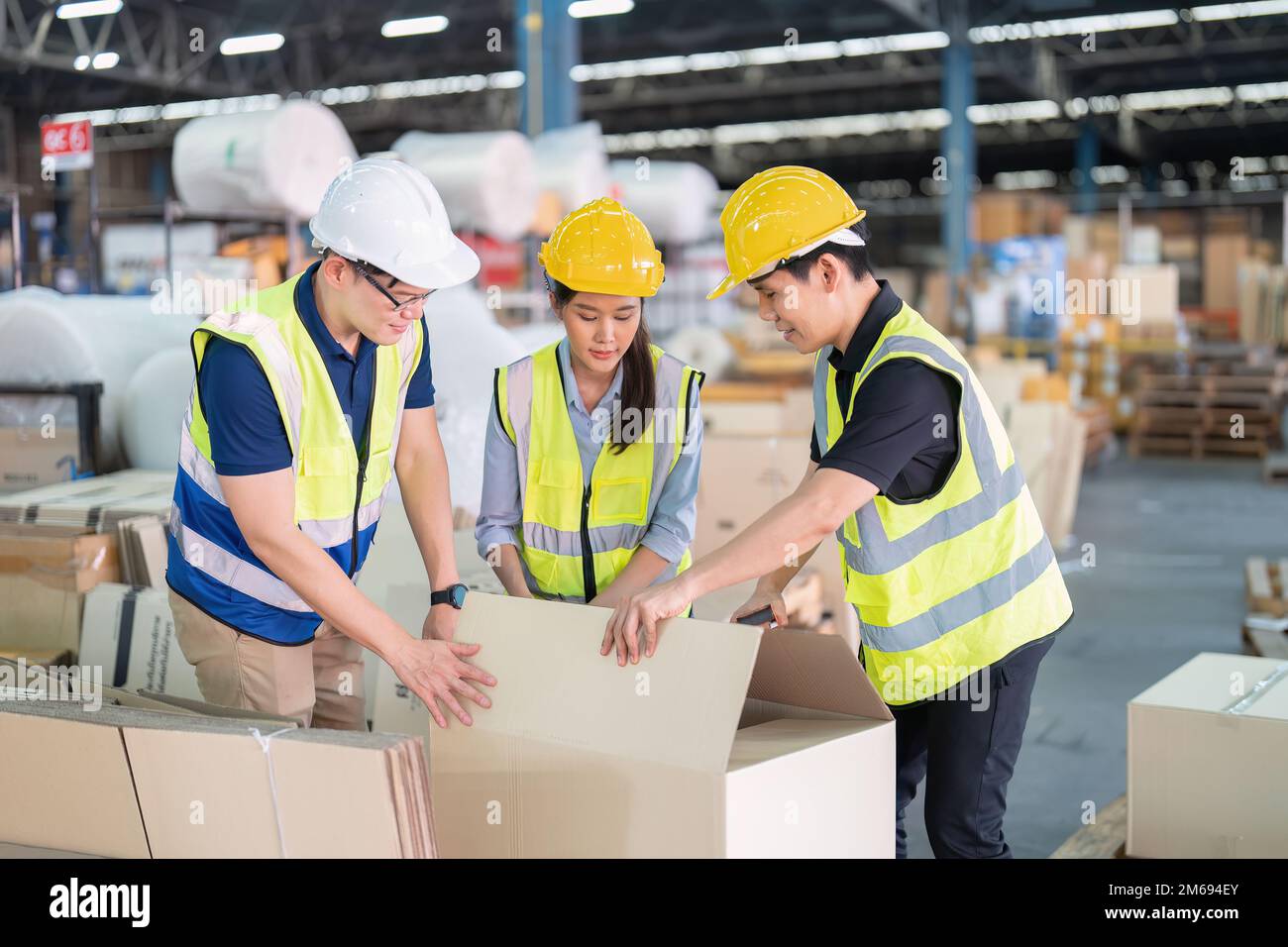Staff in large storage warehouse together packing goods and carry ...