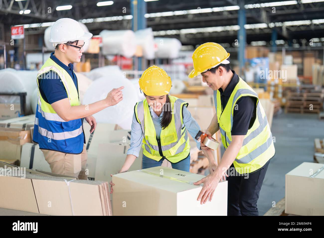 Staff in large storage warehouse together packing goods and carry ...