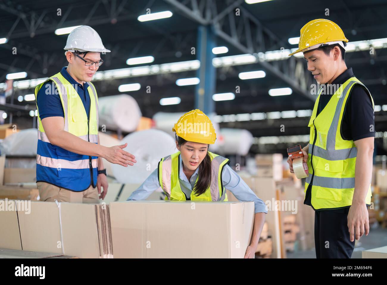 Staff in large storage warehouse together packing goods and carry ...
