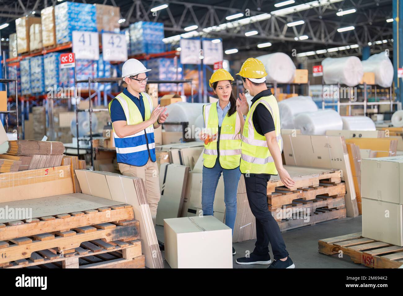 Staff in large storage warehouse together packing goods and carry ...