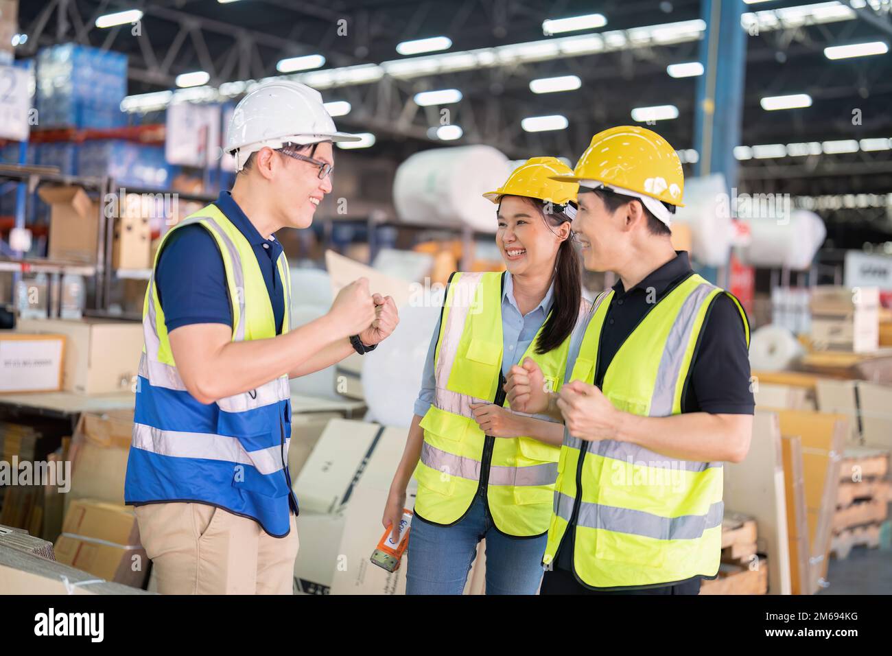 Staff in large storage warehouse together cheerful after work completed ...