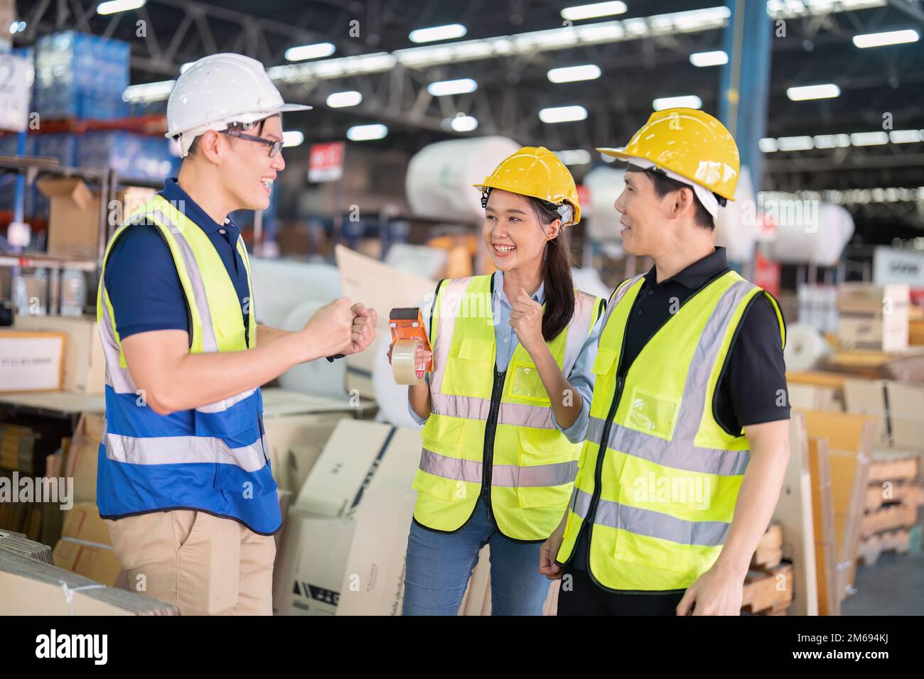 Staff in large storage warehouse together cheerful after work completed ...