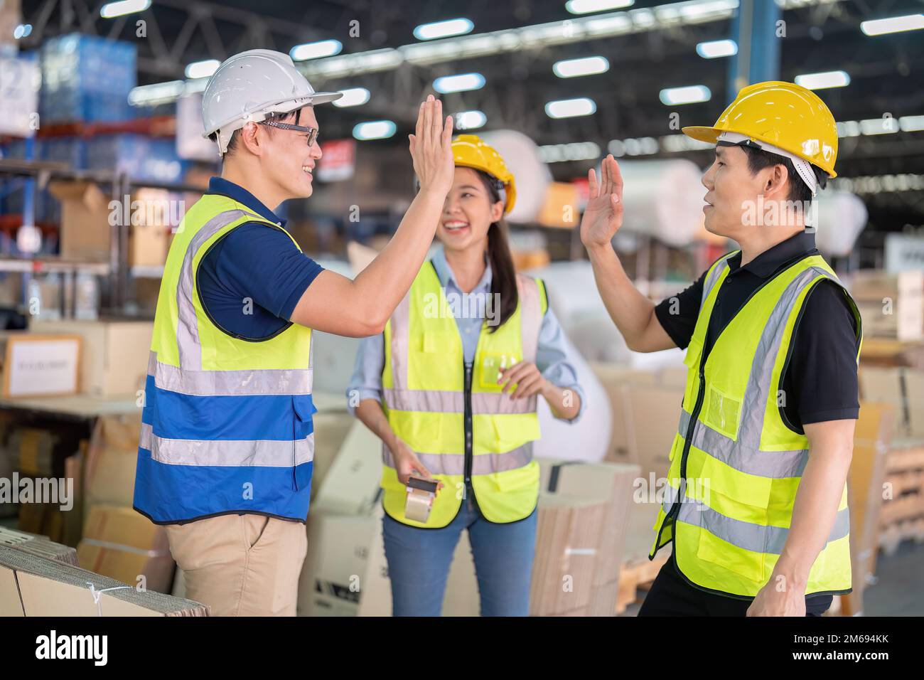 Staff in large storage warehouse together cheerful after work completed ...
