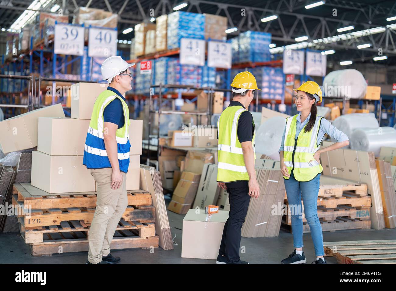 Staff in large storage warehouse together cheerful after work completed ...