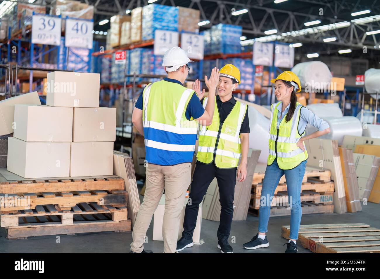 Staff in large storage warehouse together cheerful after work completed ...