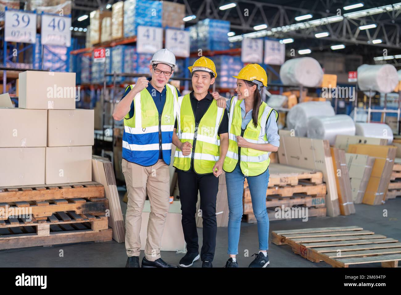 Staff in large storage warehouse together group portrait after work ...
