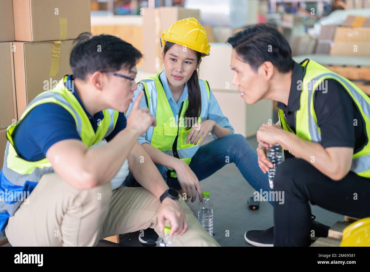Staff in large storage warehouse together sit back relax cheers ...