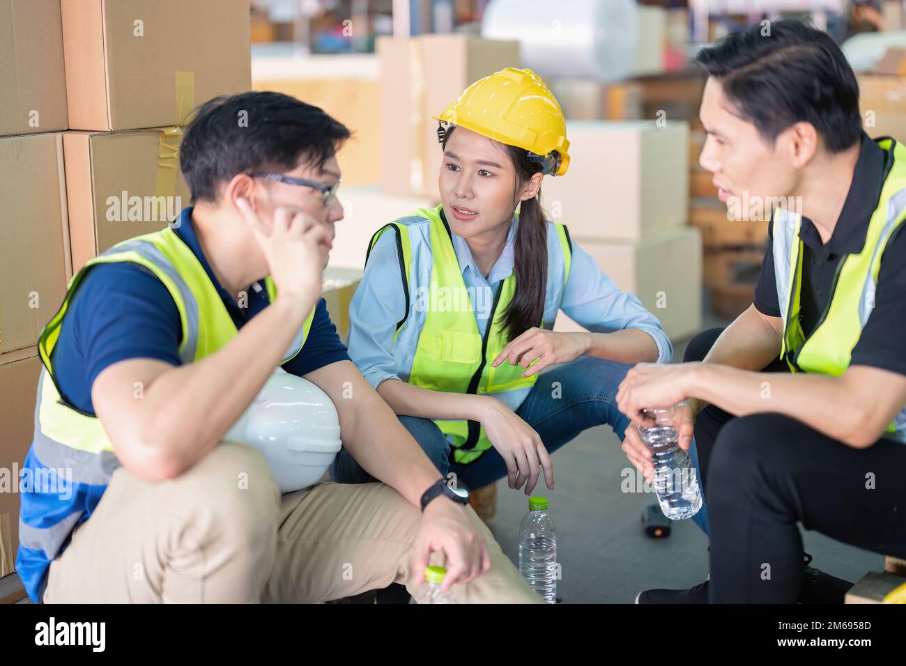 Staff in large storage warehouse together sit back relax cheers ...