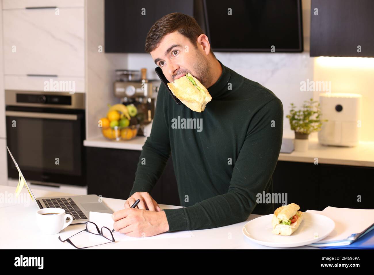 Busy man eating a sandwich while on conference call Stock Photo - Alamy