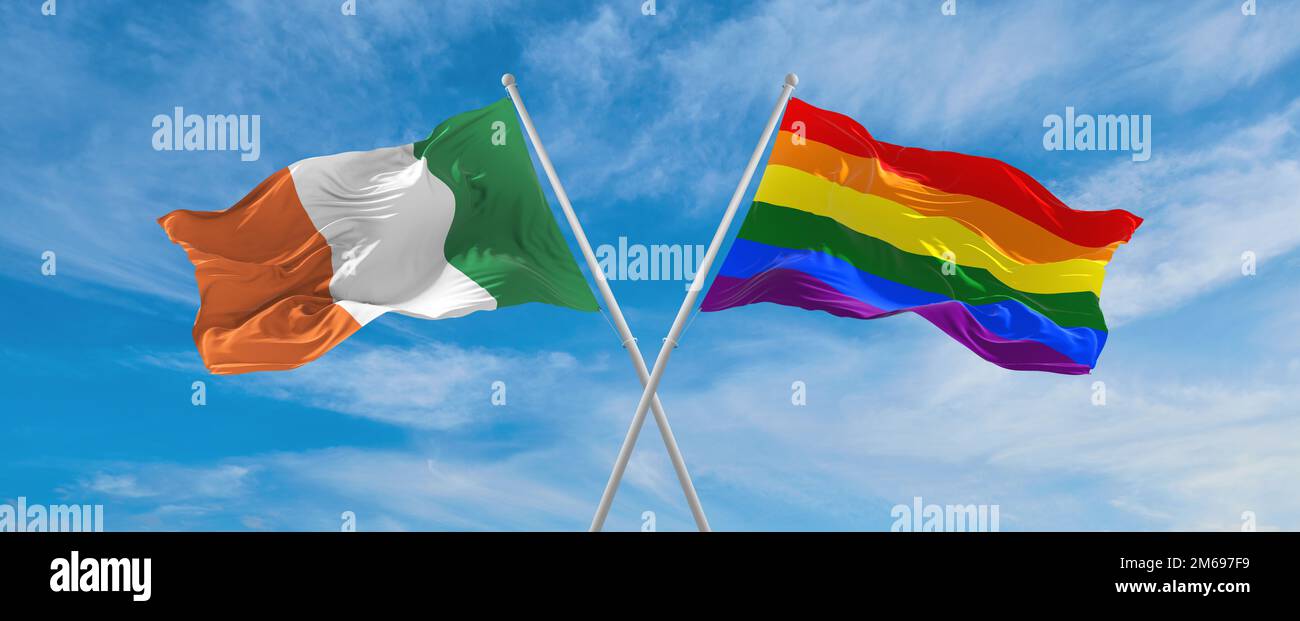 two crossed flags LGBT Pride and Ireland waving in wind at cloudy sky ...