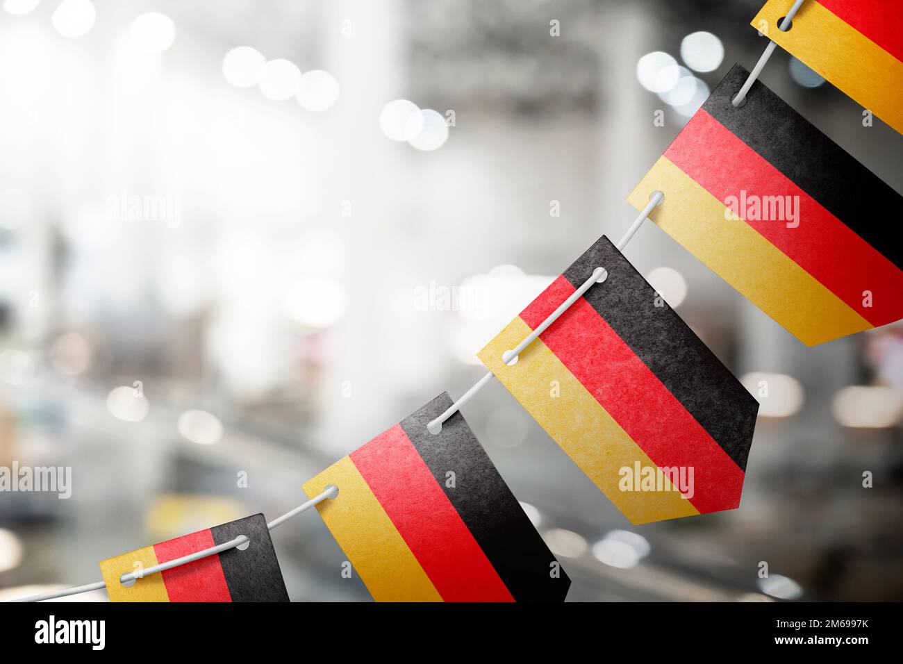 A garland of Germany national flags on an abstract blurred background ...