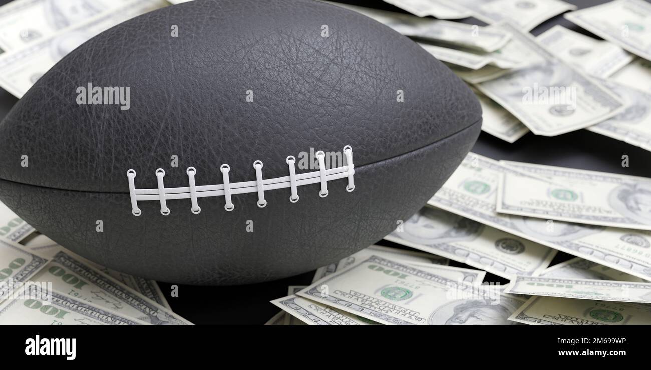 American football ball on a stack of dollars money Stock Photo - Alamy