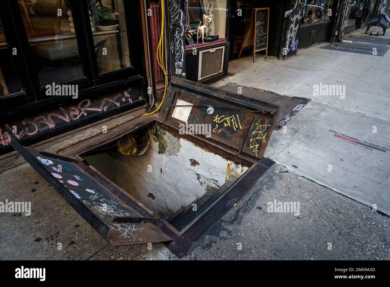 Open cellar door in the sidewalk, The Bowery, a historic neighbourhood ...